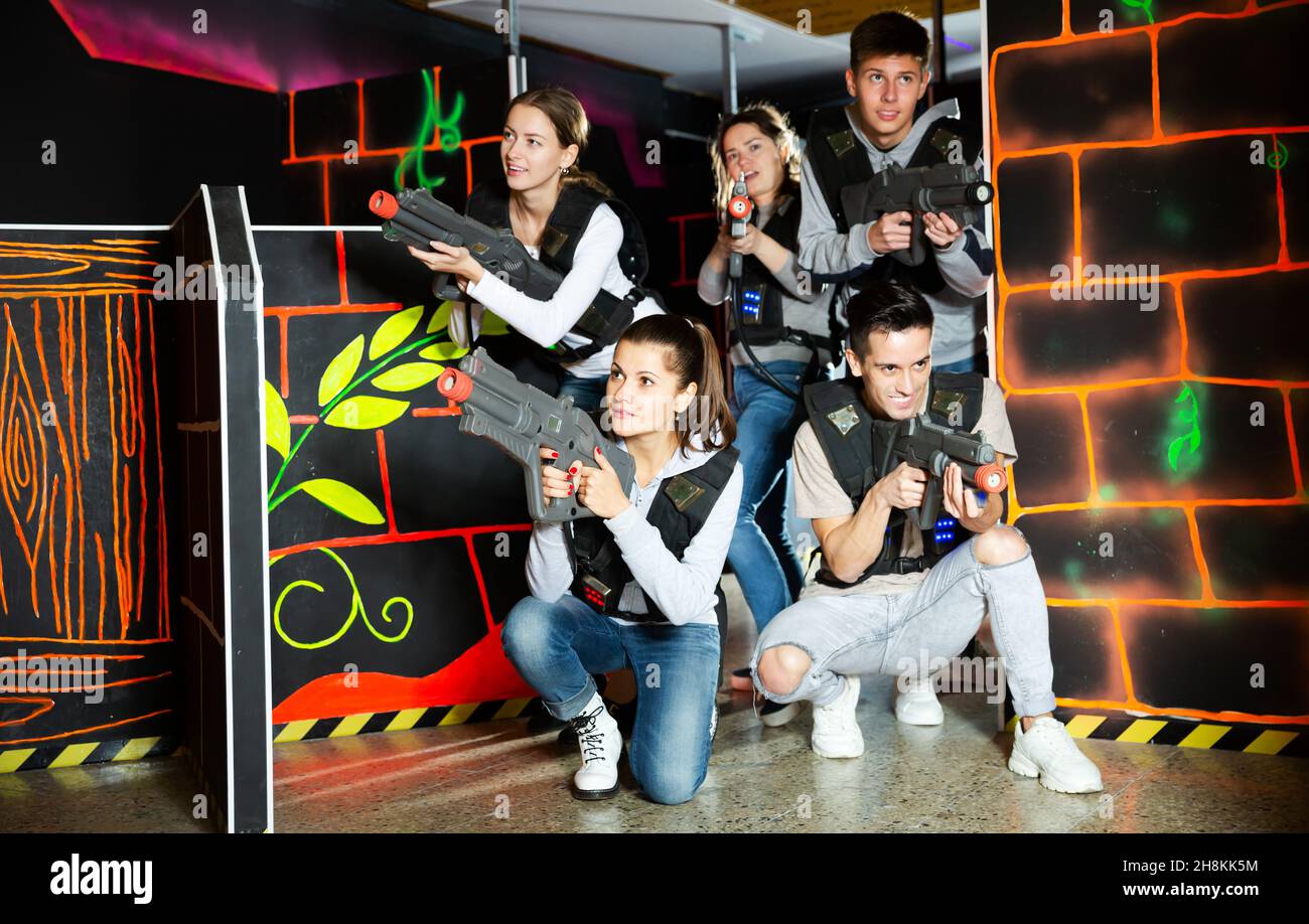 Group glad people playing laser tag game Stock Photo - Alamy