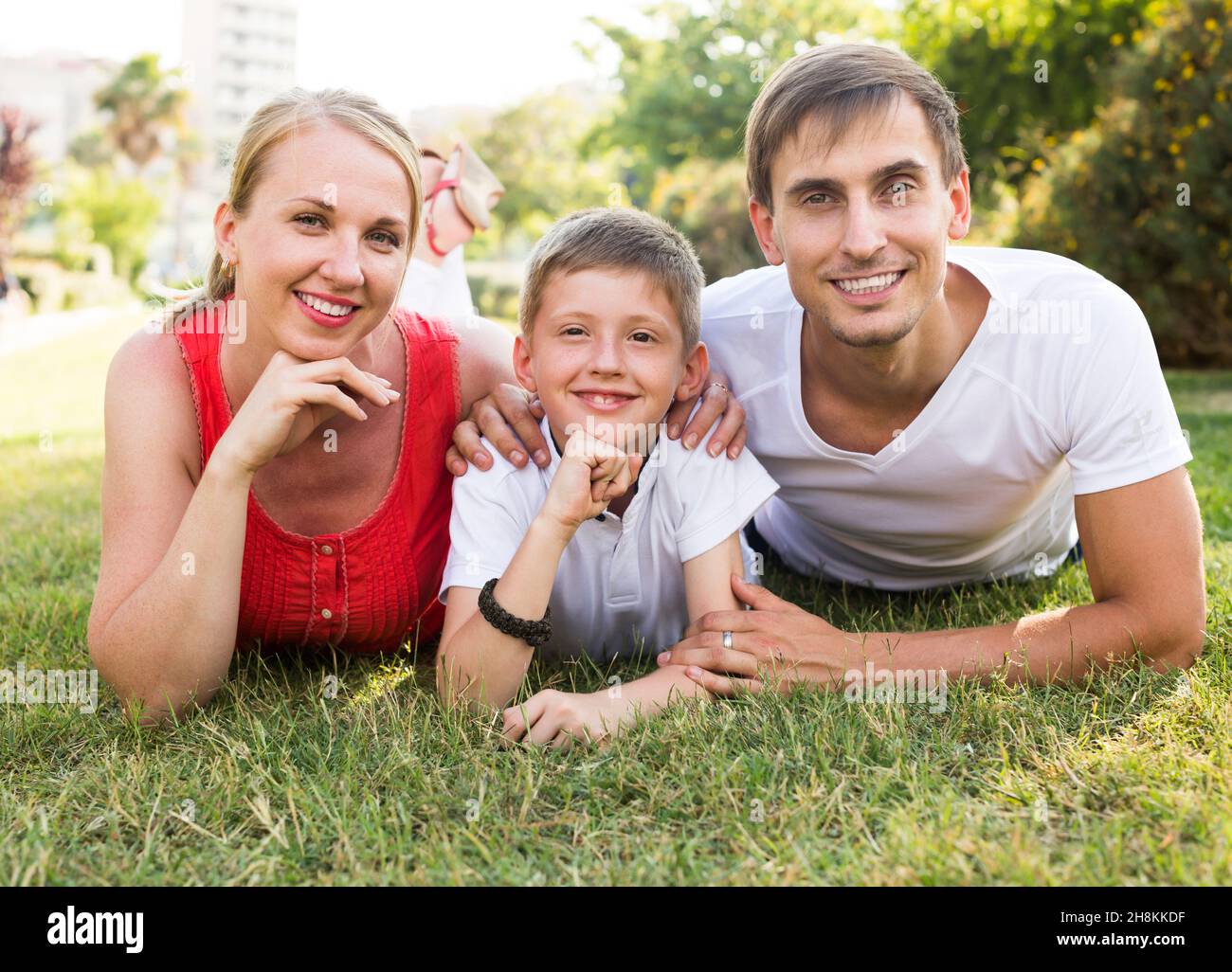 Portrait of family with boy lying in park Stock Photo - Alamy