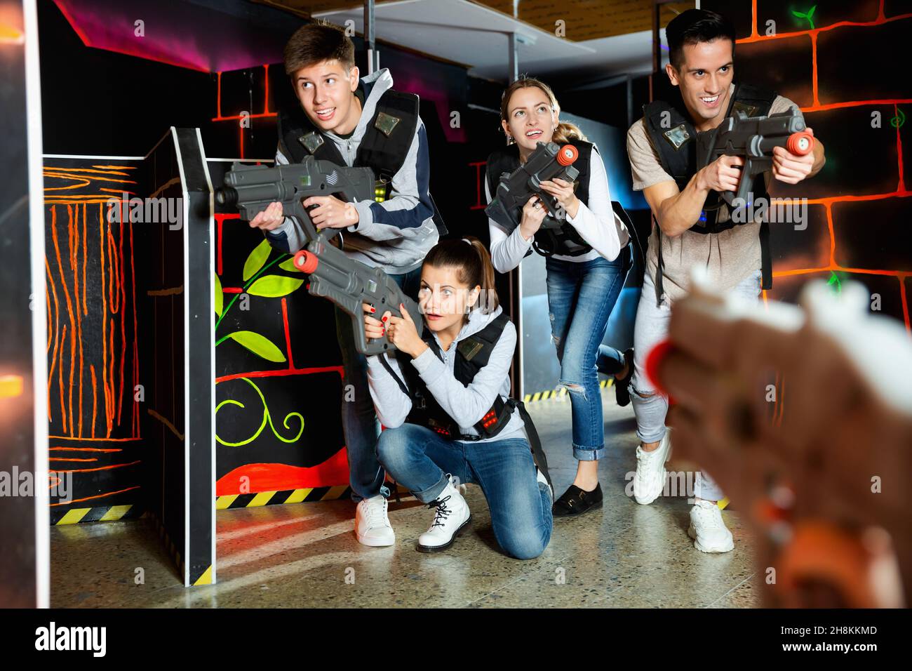 Ordinary Laser tag players young mens and womens playing in teams in ...
