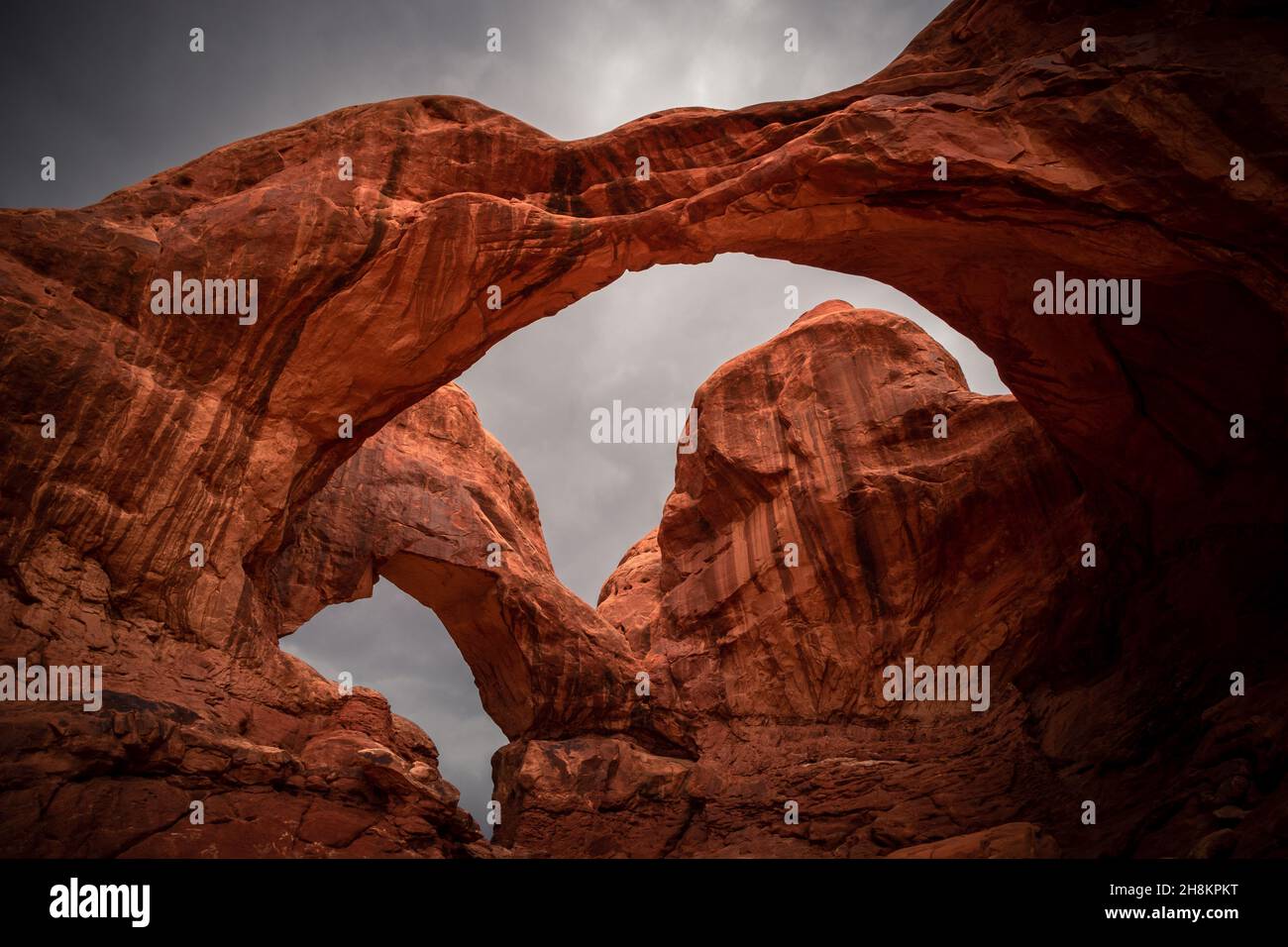 View of Double Arch, storm clouds in the sky, Arches National Park ...