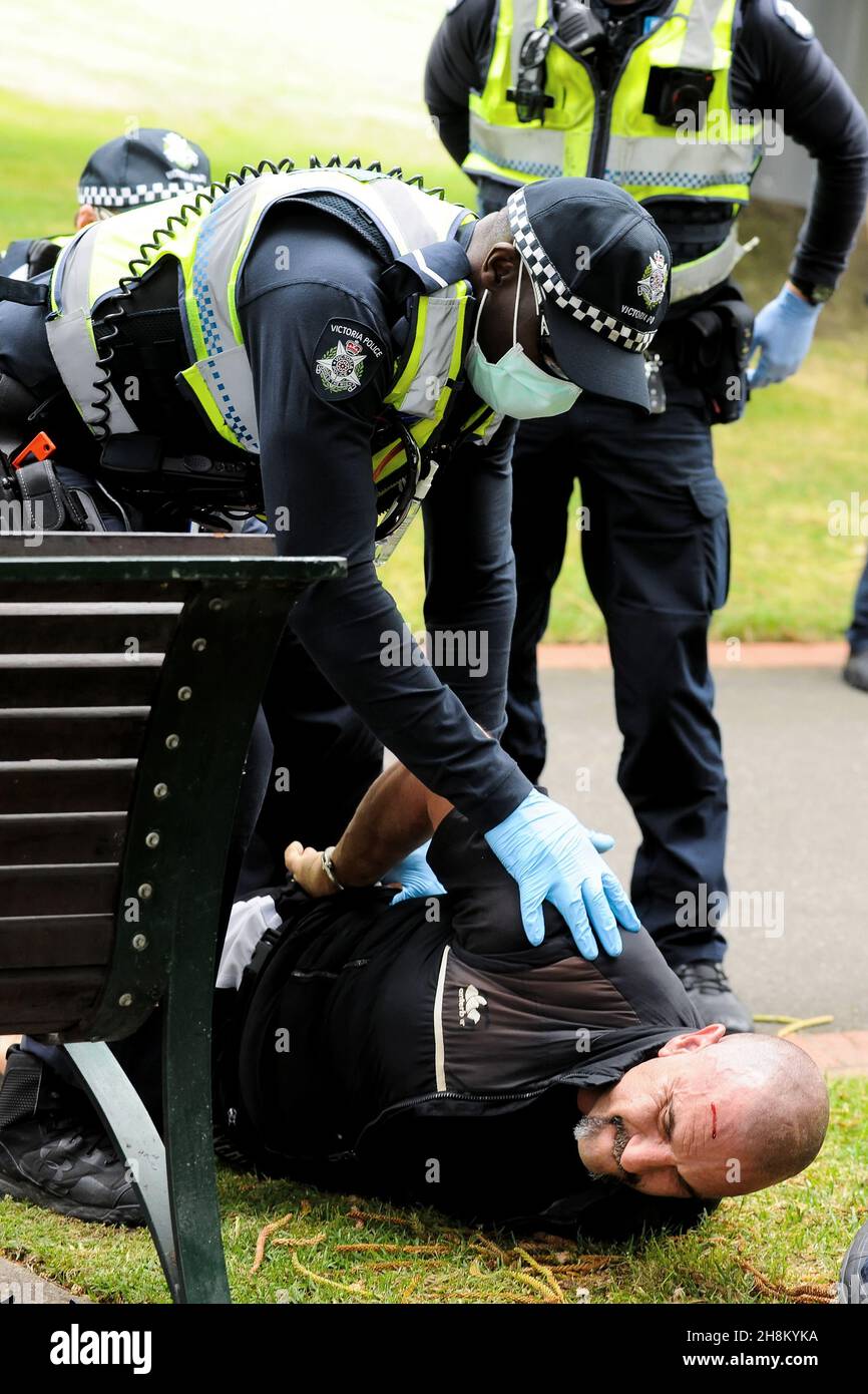 A man bleeding from the forehead is rolled over by a police after ...