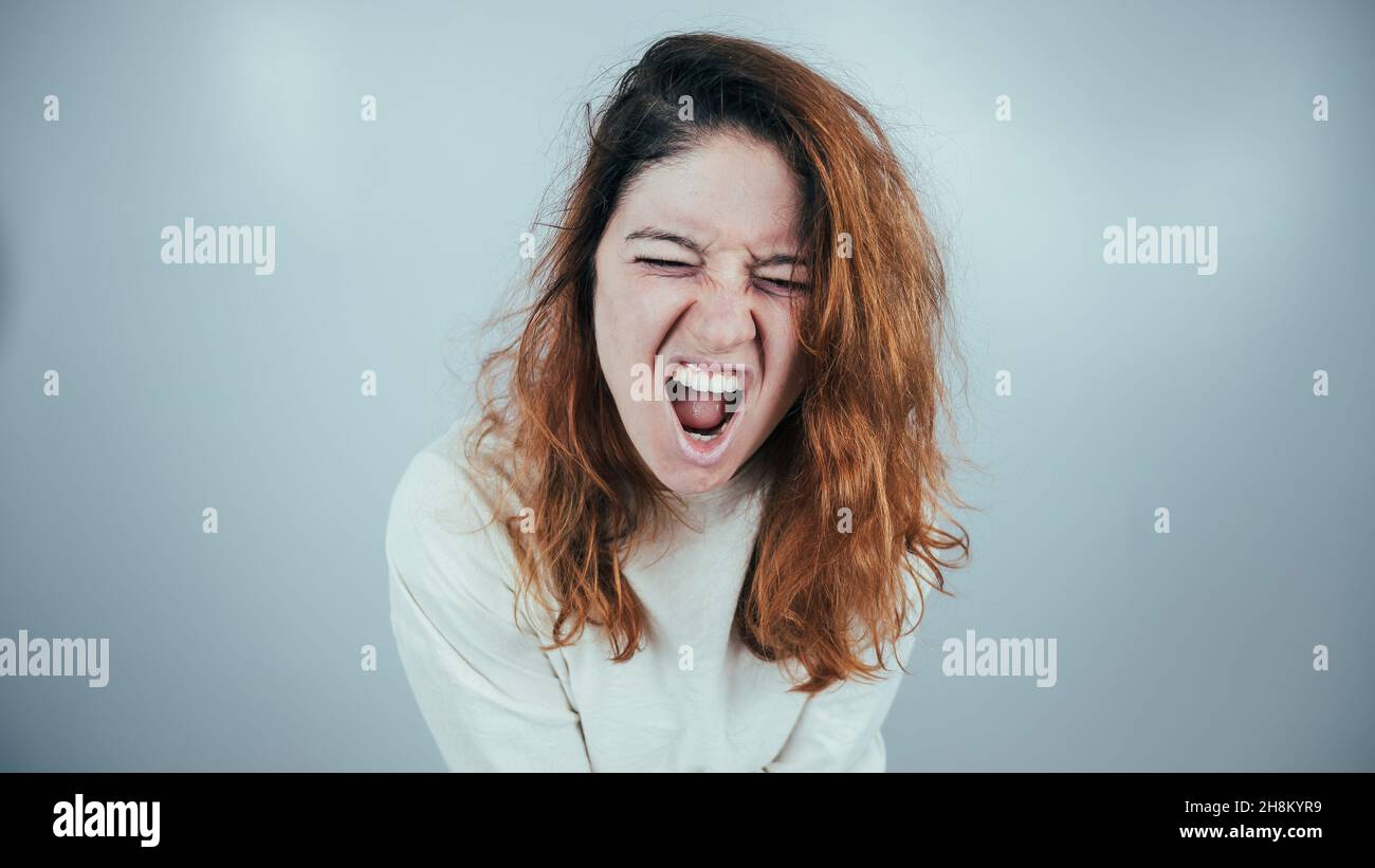 Close-up portrait of insane woman in straitjacket on white background ...