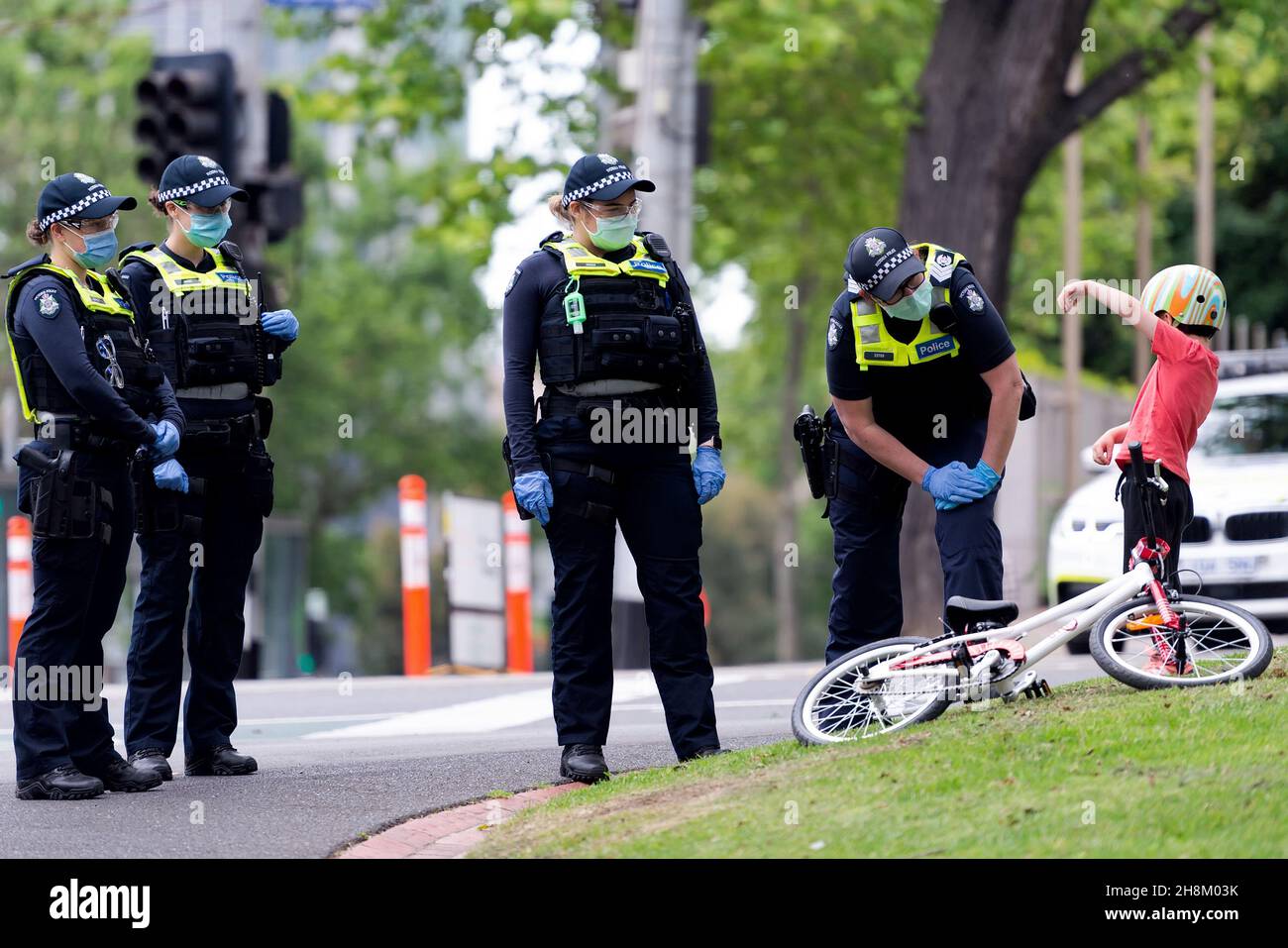 Police officers interact with a young boy riding his bicycle ...