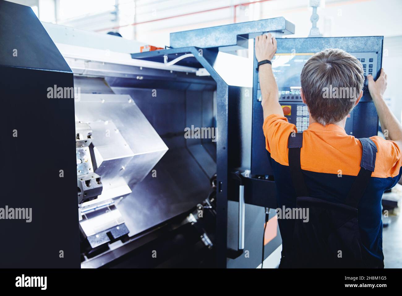 Worker use tool on lathe machine on factory floor. Industry portrait ...