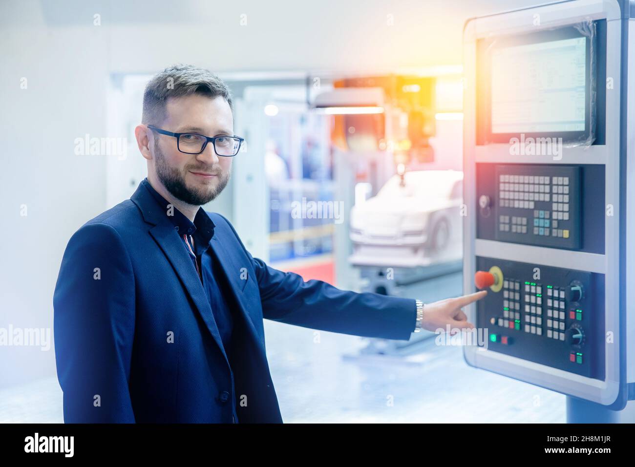 Industrial worker man in glasses operating CNC laser turning machine at ...