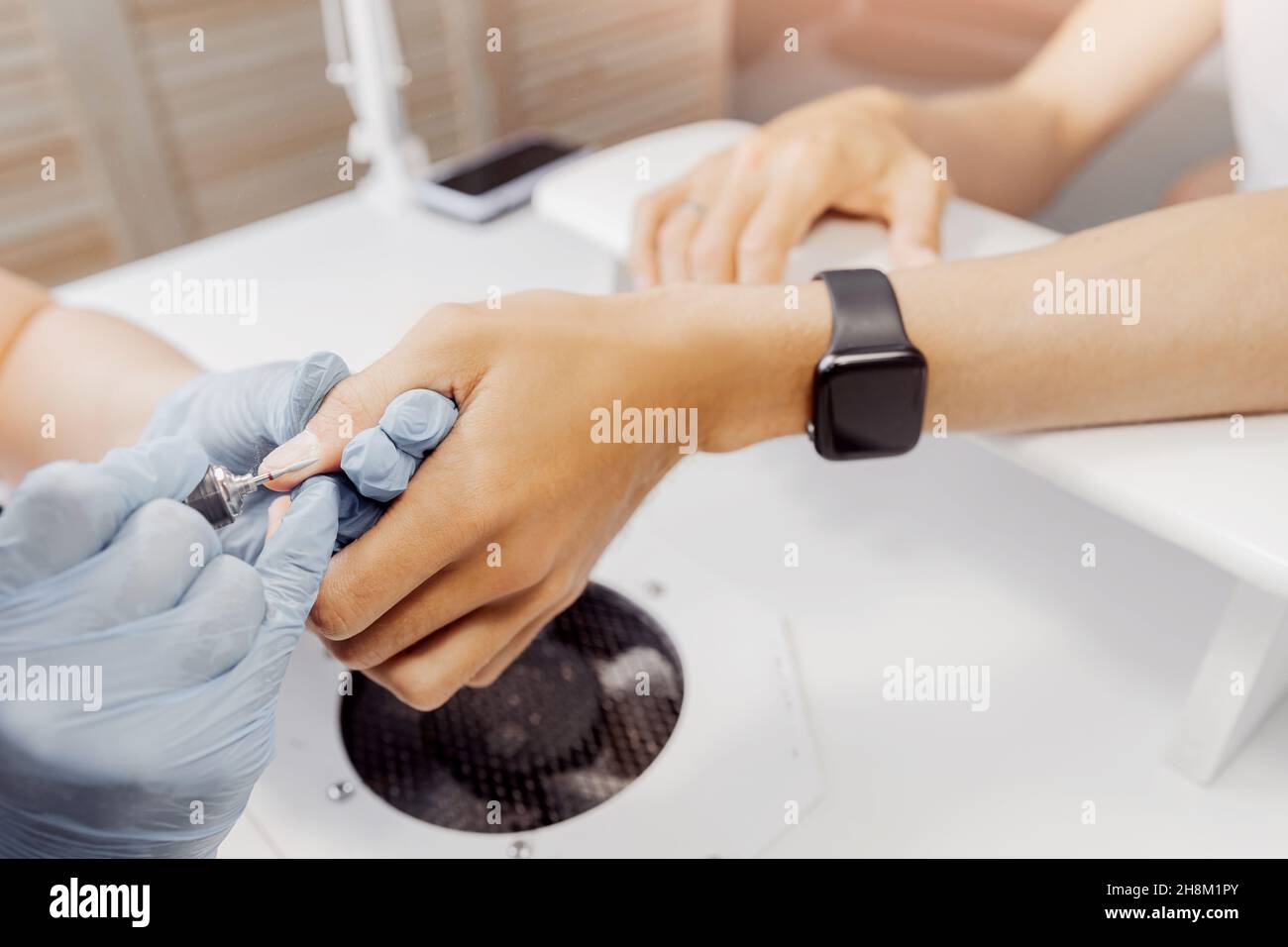 Closeup hands of young man gets professional manicure in spa salon ...