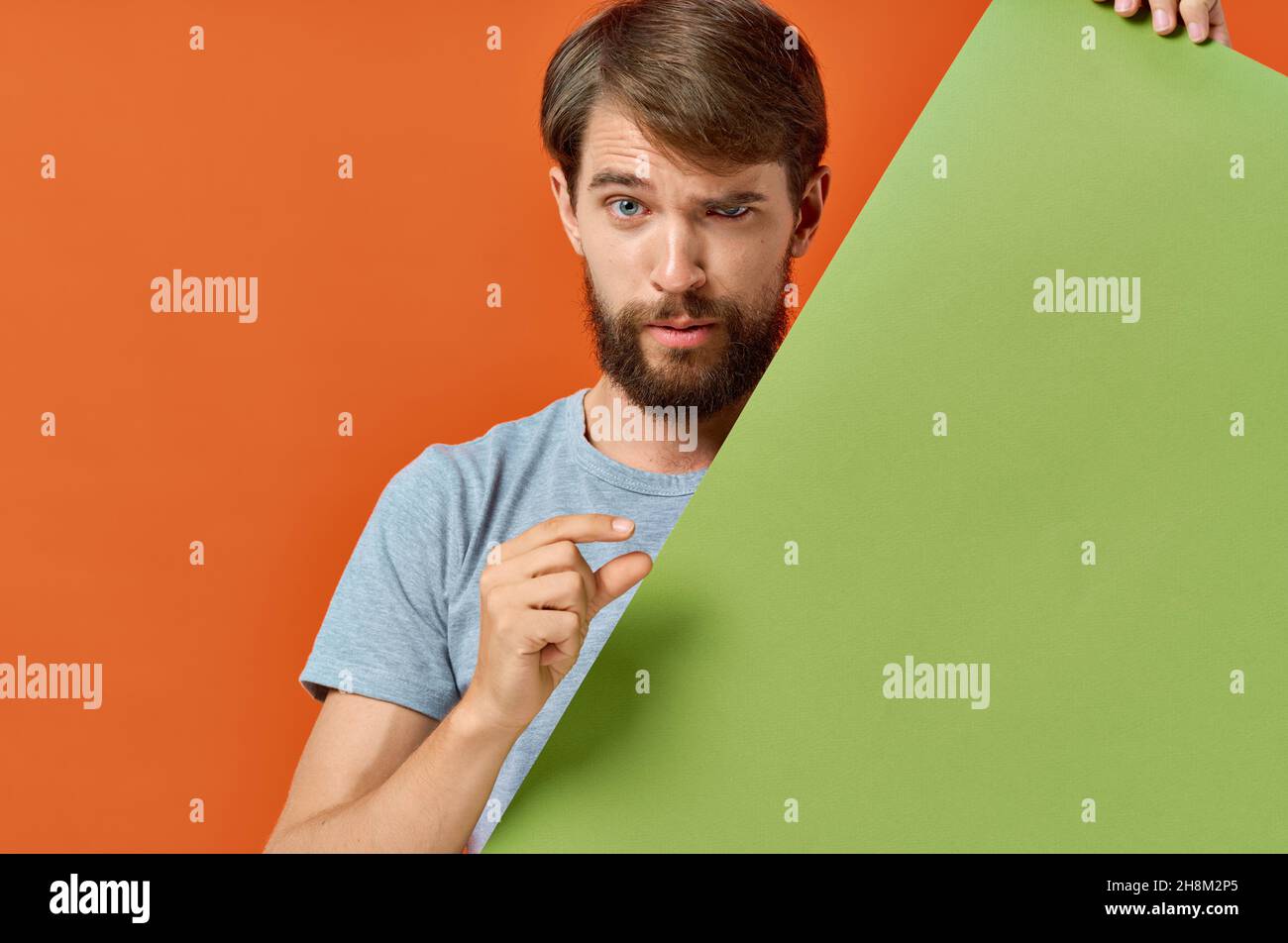 bearded man holding a green banner design orange background Stock Photo ...