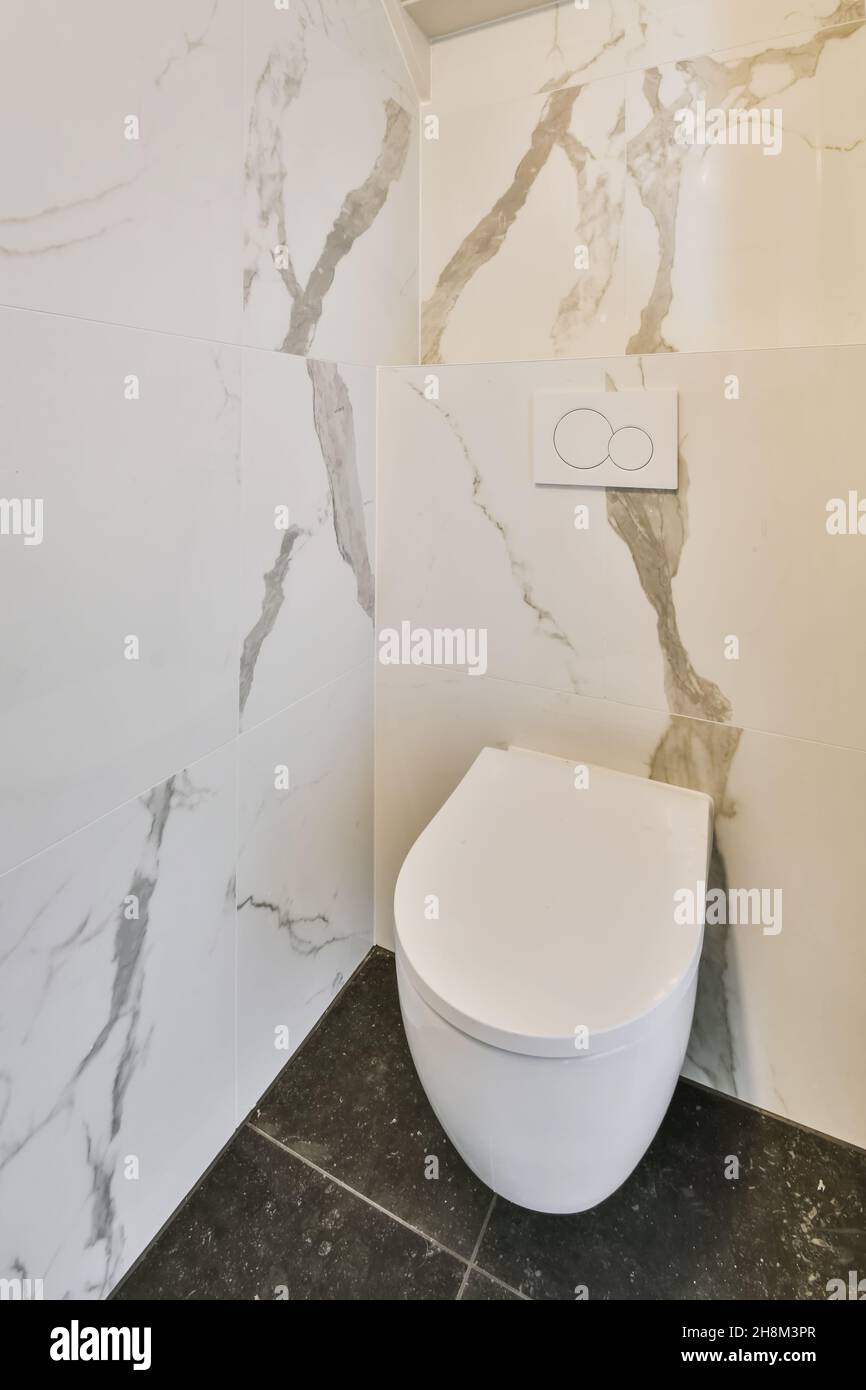 Small restroom with marble walls and floor Stock Photo - Alamy