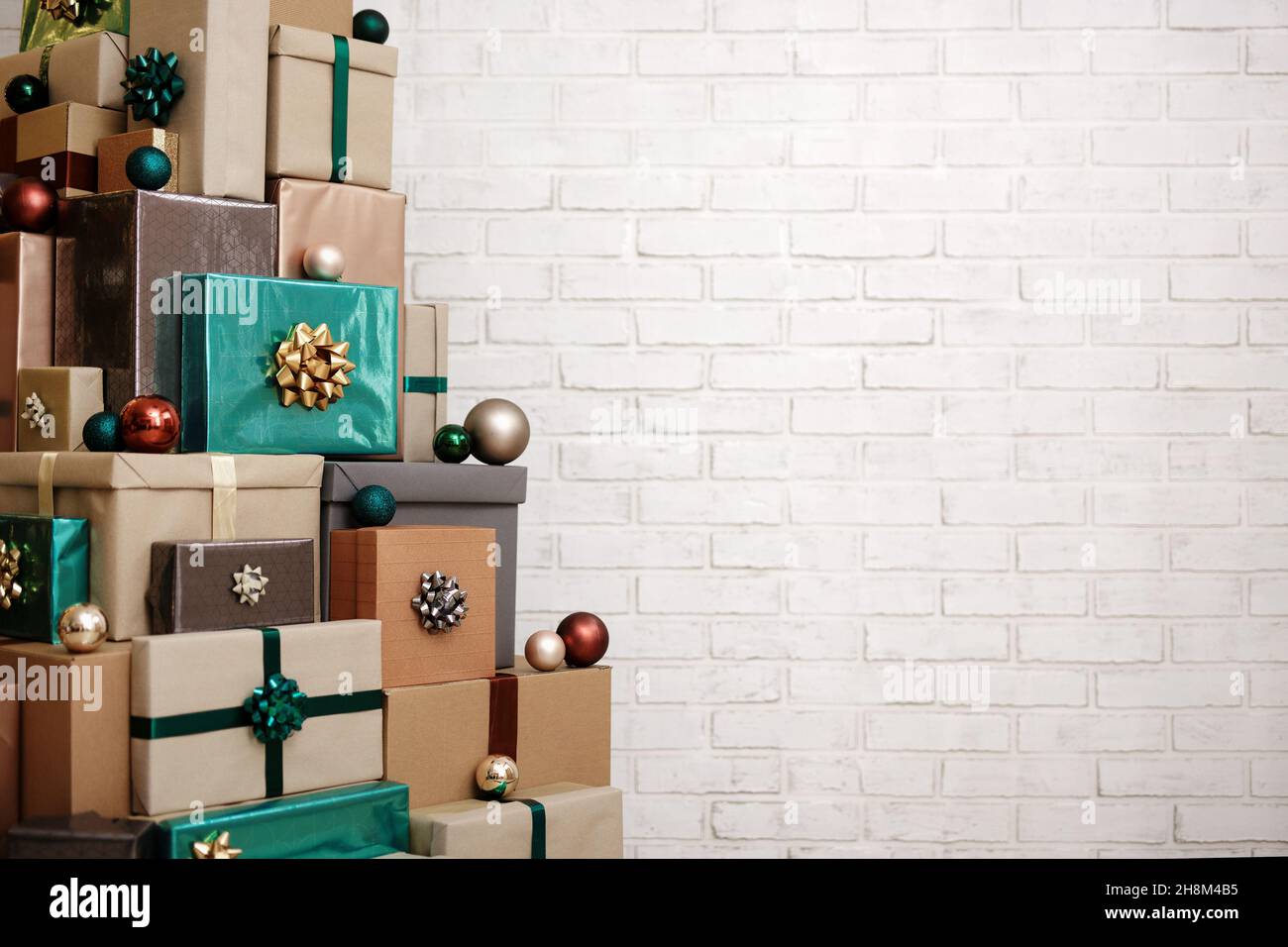close up of Christmas gift boxes over white brick wall background with ...