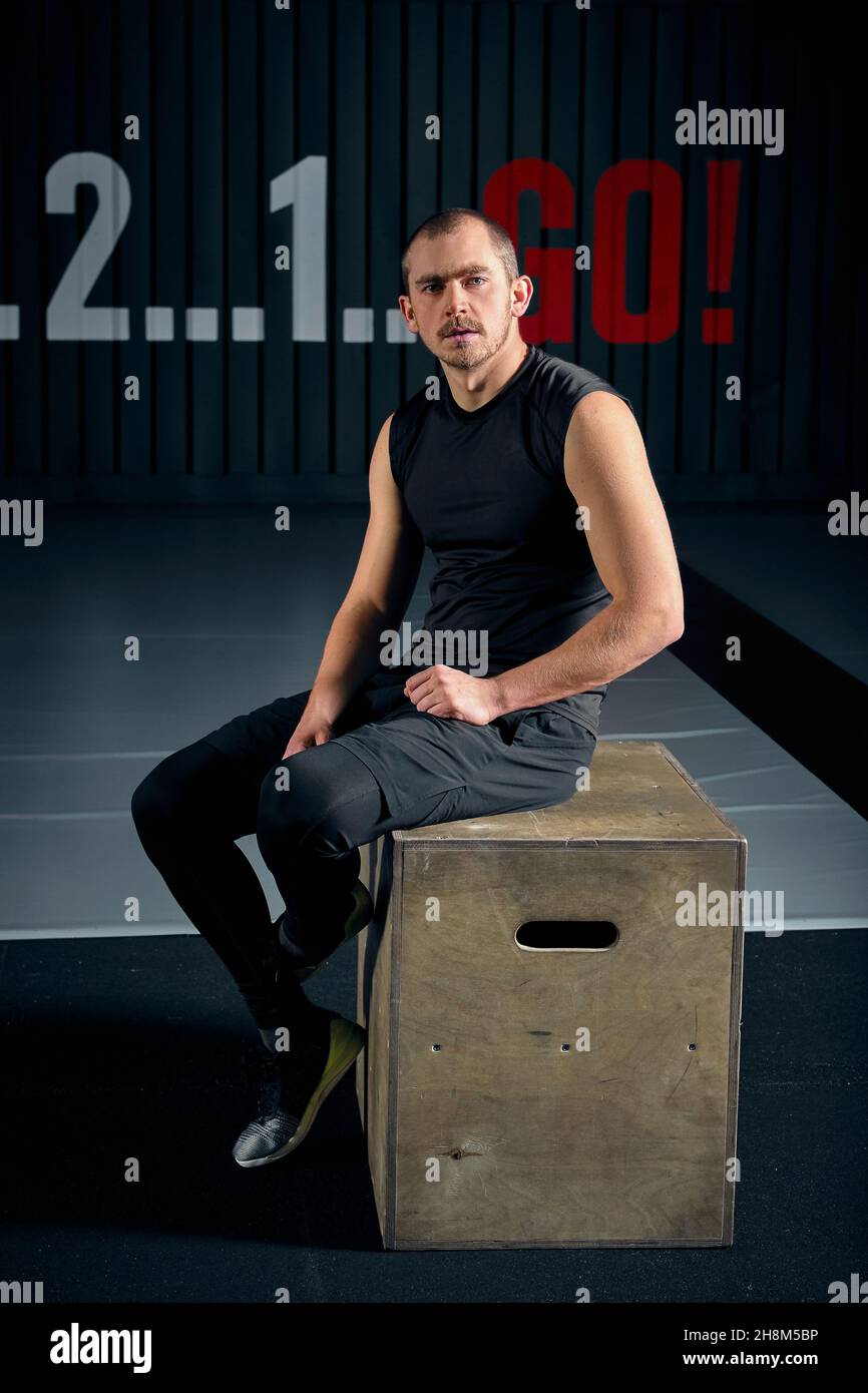 Bodybuilder sitting on the wooden box at the gym Stock Photo - Alamy