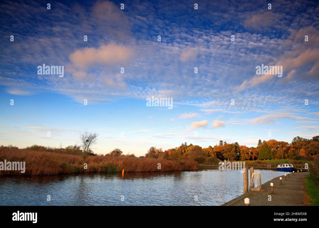 A view of the River Ant in autumn on the Norfolk Broads with mooring ...
