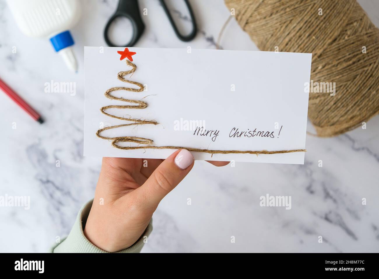 Christmas tree made of rope. Top view of hands making step by step ...