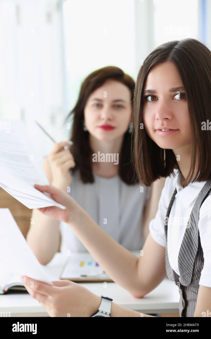 Business women working on monthly report surrounded with bunch of ...