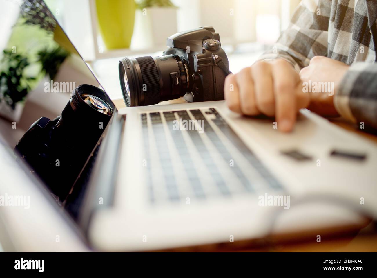 Photographer retouching photos on his computer. Work in progress after ...