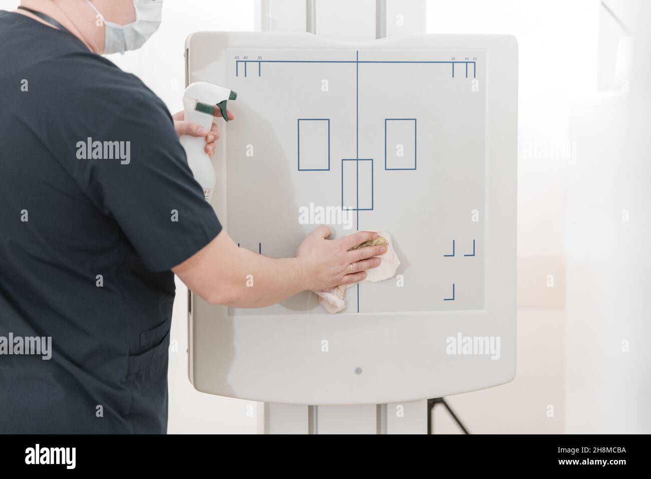 Doctor cleans the X-ray machine. X-ray department in modern hospital ...