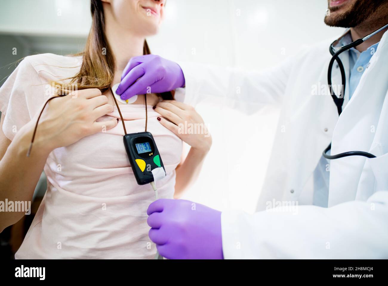 Young smiling woman wearing a holter heart monitor Stock Photo - Alamy