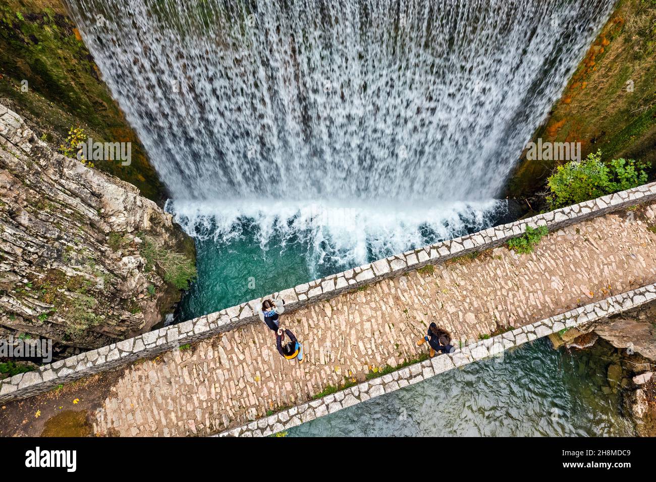 The old stone, arched bridge, between two waterfalls in Palaiokaria ...