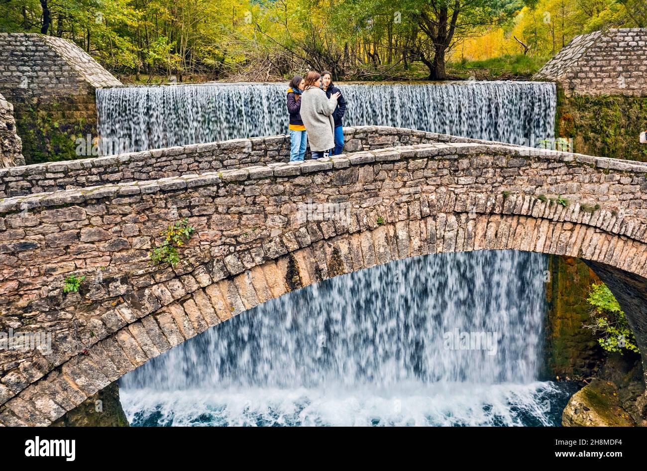 The old stone, arched bridge, between two waterfalls in Palaiokaria ...