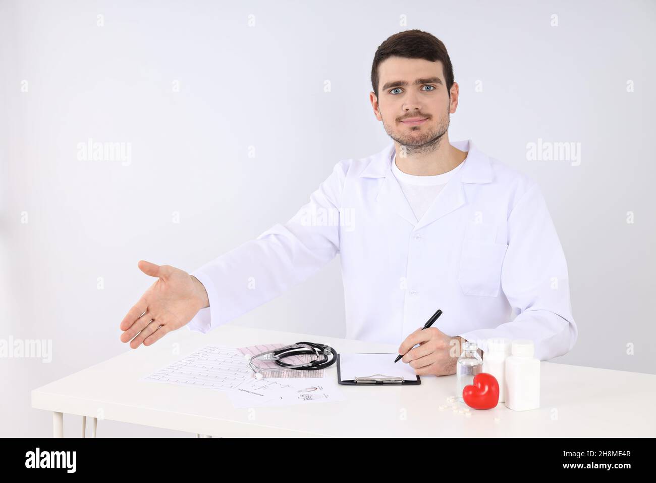Doctor intern sitting at workplace on white background Stock Photo - Alamy