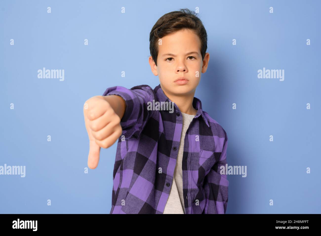 Cute Caucasian kid boy wearing plaid shirt against purple background ...