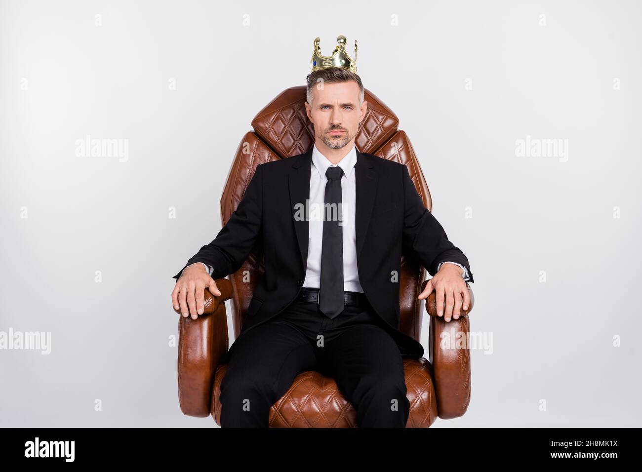 Photo of serious handsome young agent wear black jacket gold crown ...
