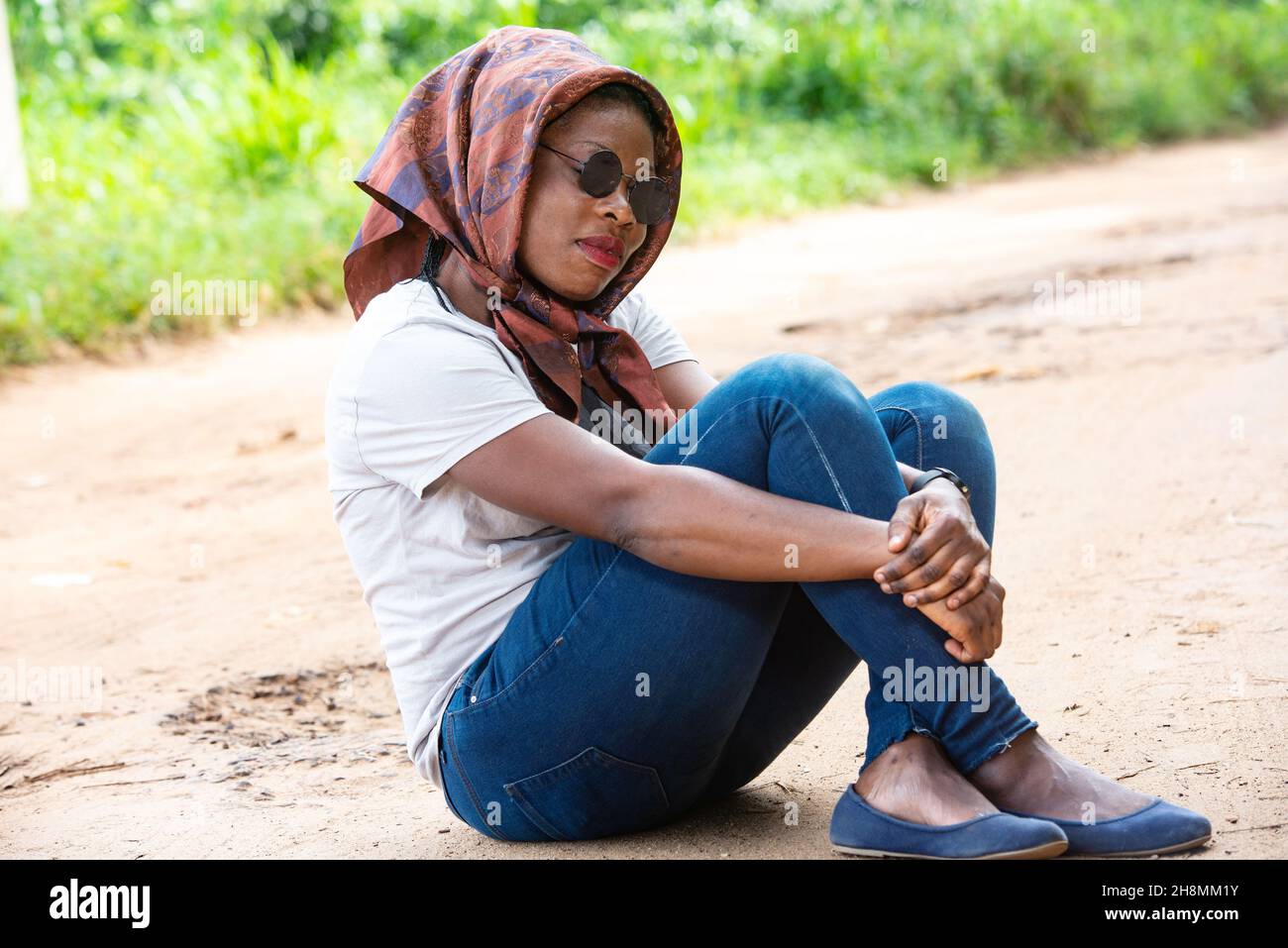 African woman sitting hands on legs hi-res stock photography and images ...