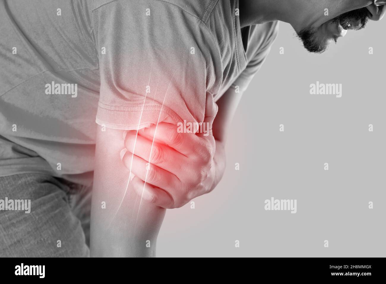 Asian man with pain in the humerus on a gray background Stock Photo - Alamy