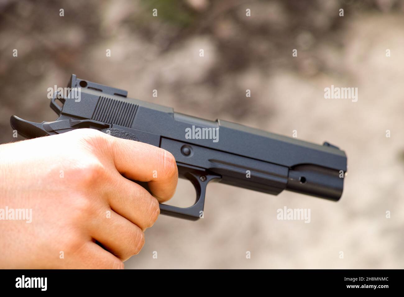 A Realistic black airsoft gun in person hand. Closeup Stock Photo - Alamy