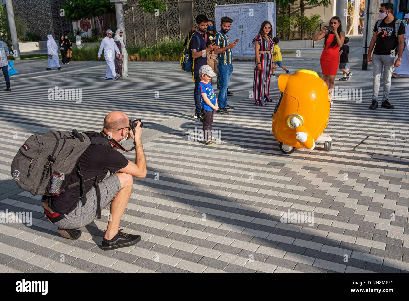 A little boy meets Opti the mascot robot at Expo 2020 while his dad ...