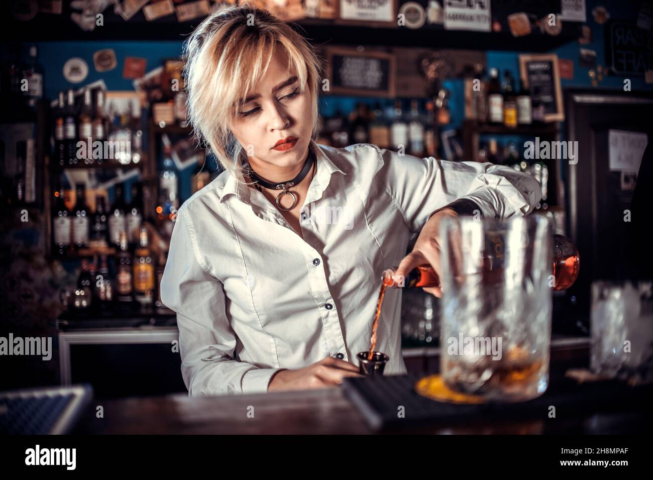Focused woman bartending makes a cocktail at the bar counter Stock ...