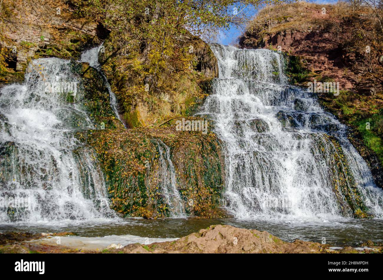 Waterfall flowing in two streams from the hill. Beautiful landscape ...