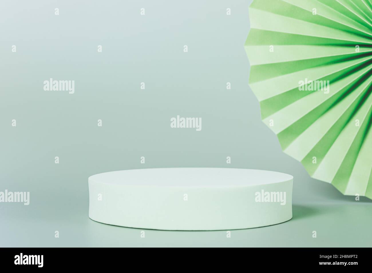 Round empty podium pedestal template with paper origami fan on light ...