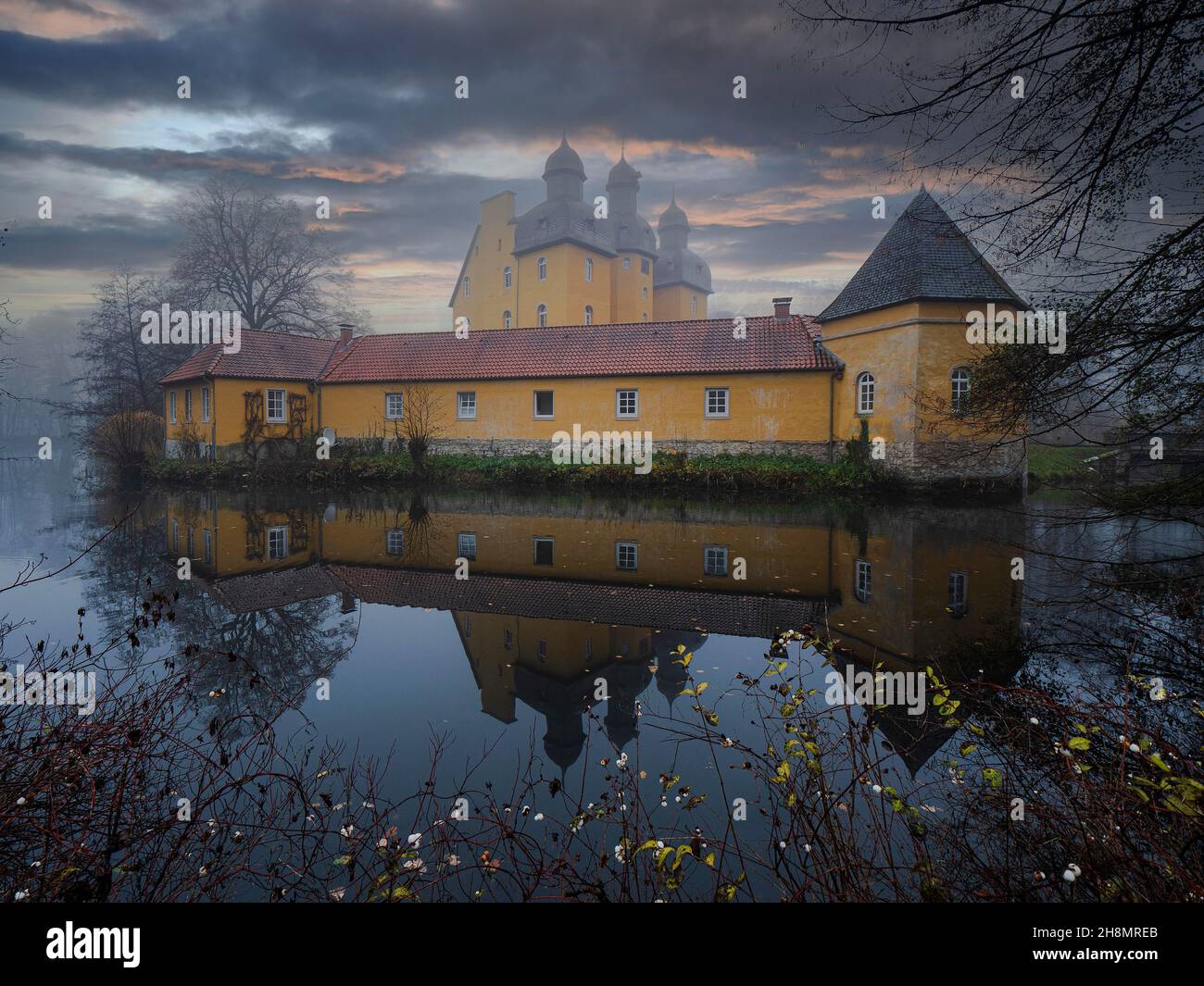 Schloss-Holte moated castle in autumn as fog rolls in, North Rhine ...