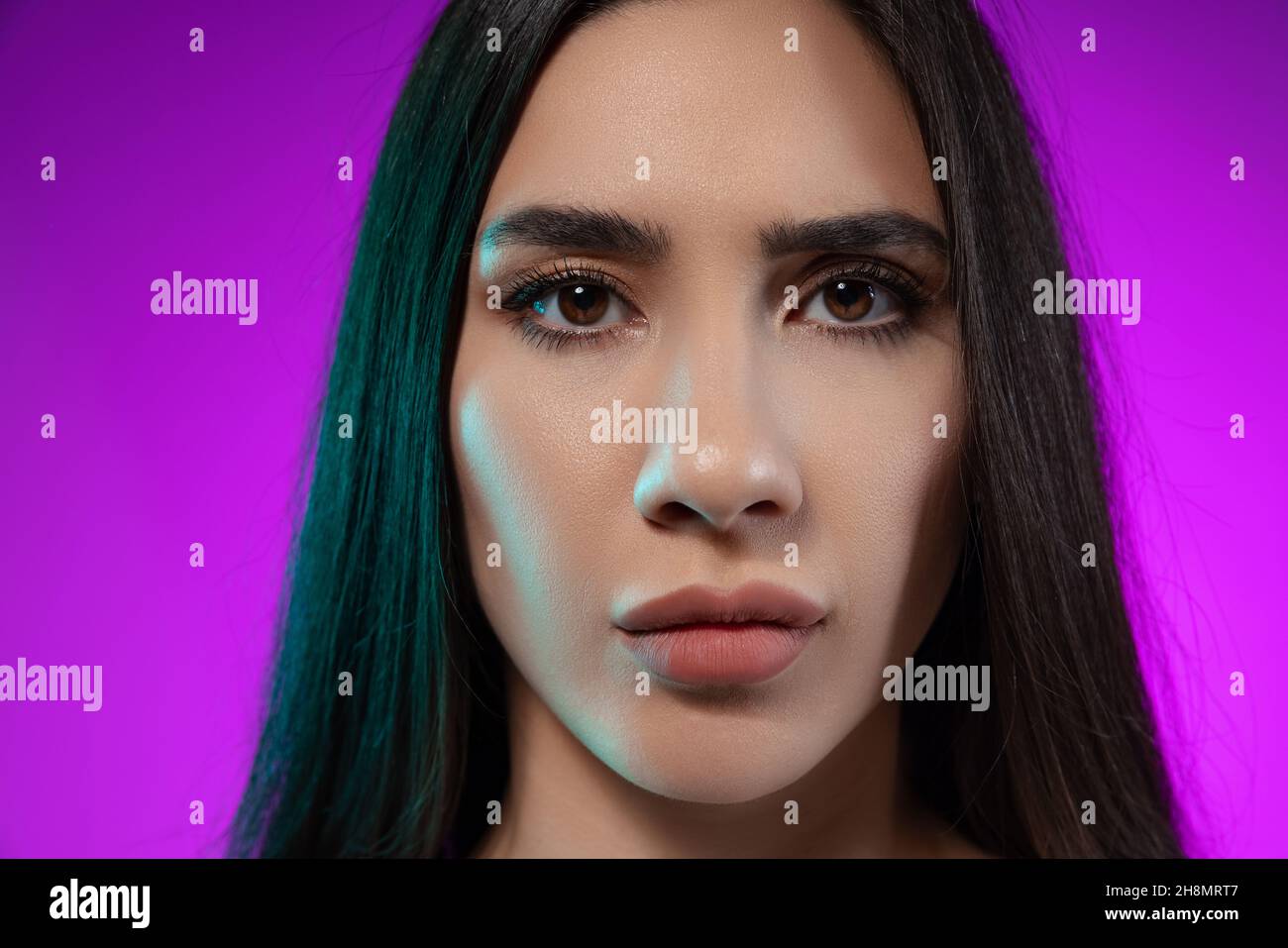 Close-up portrait of beautiful girl seriously looking at camera, posing ...