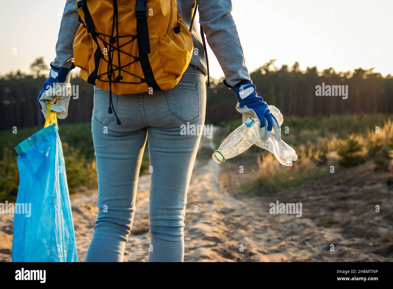 Volunteer cleaning nature from plastic pollution. Woman wearing ...