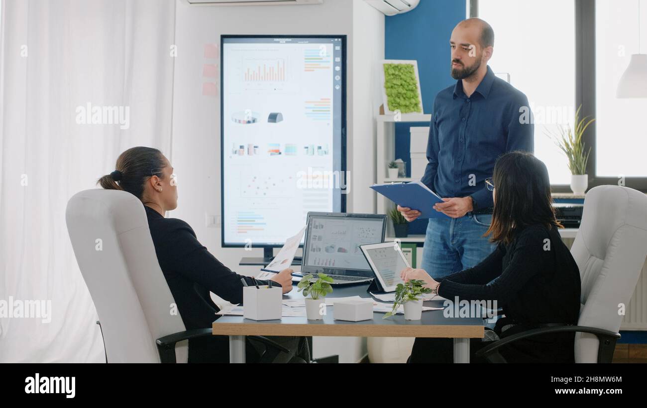Team of colleagues discussing business strategy at meeting in boardroom ...