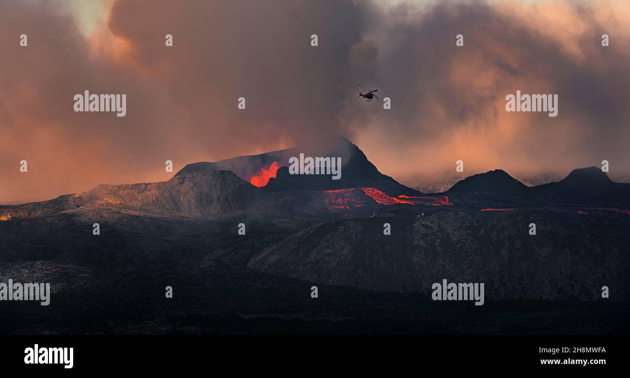 Helicopter flying over erupting volcano with lava fountains and lava ...