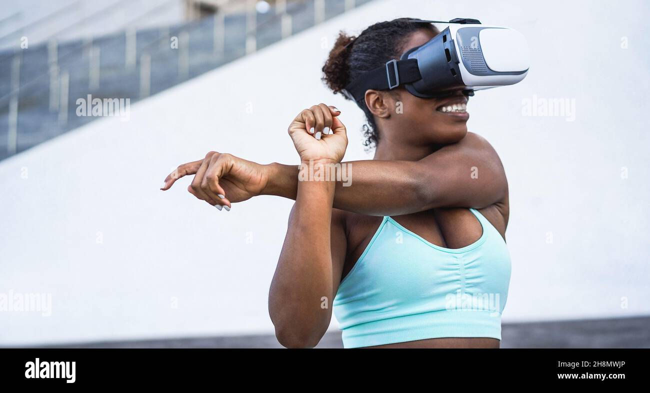 Fit african woman wearing virtual reality headset during sport workout ...