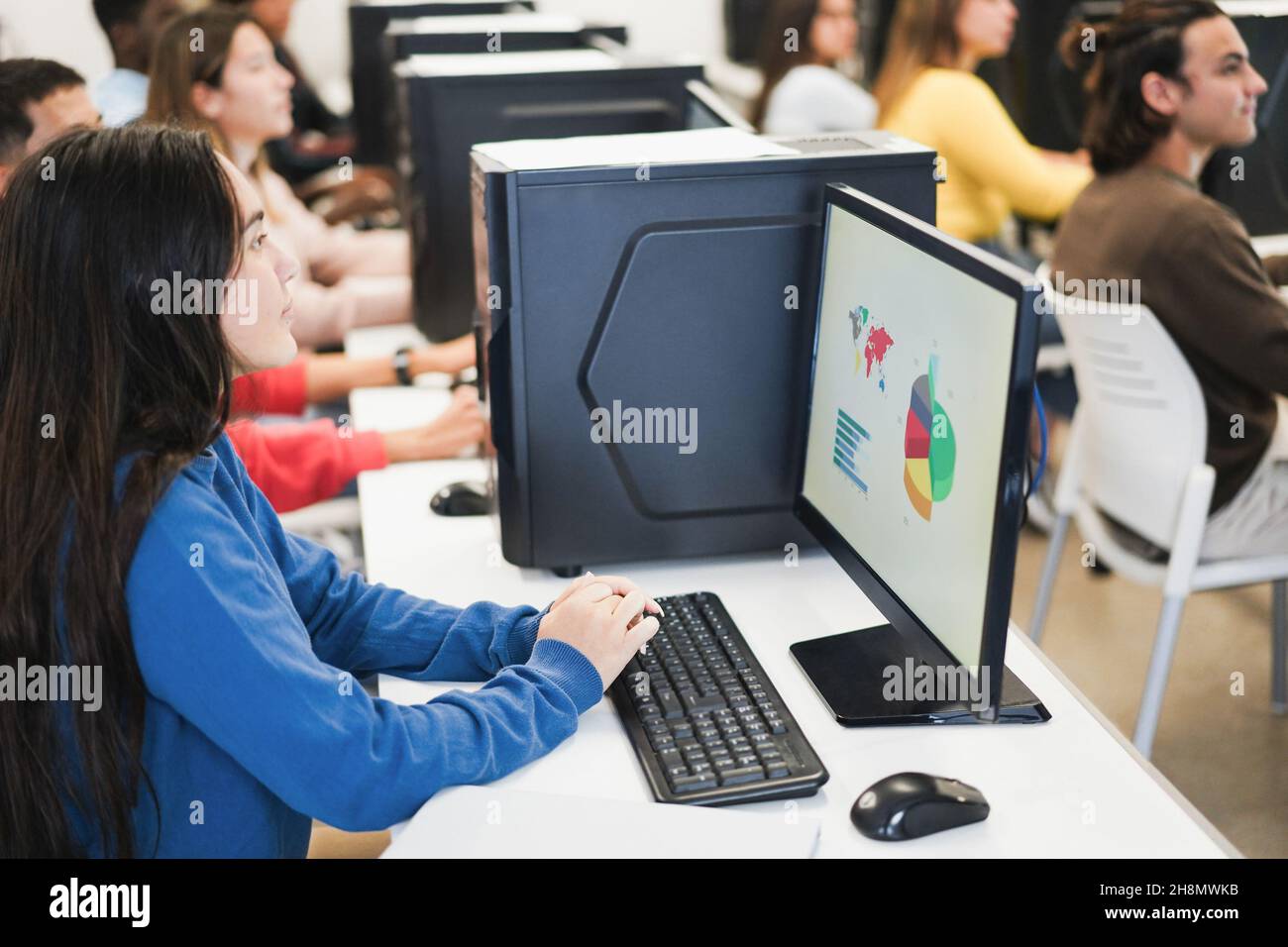 Young students using computers during business class at school - Focus ...