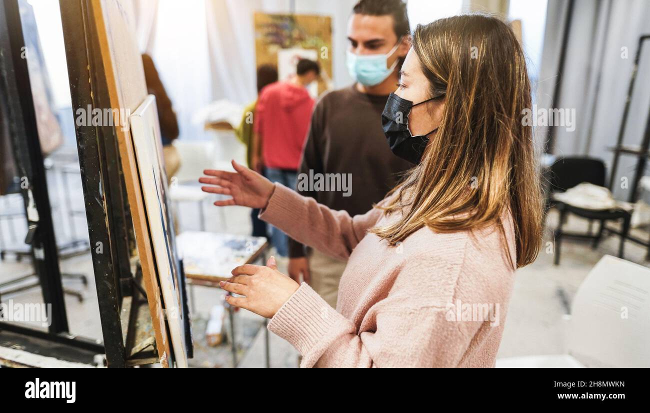 Young students painting inside art room class at college - Focus on ...