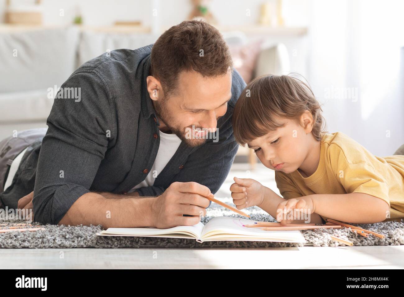 Creative kids development. Close up portrait of positive father drawing ...