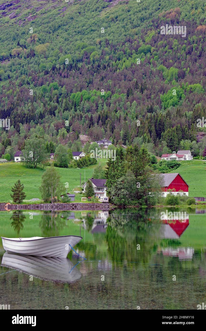 Boats and houses reflected in the shallow water of a lake, Stryn ...