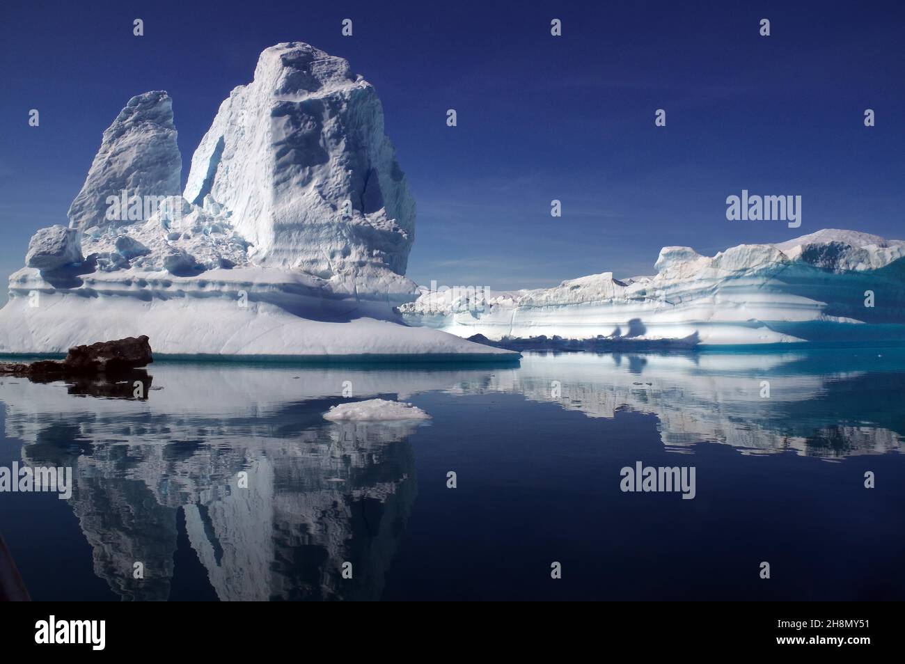 Icebergs reflected in the water, Tiniteqilaaq, Tasilaq, East Greenland ...