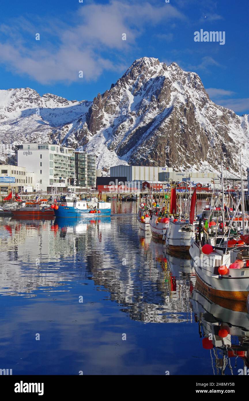 Traditional fishing boats in Svolvaer harbour, snow-capped mountains in ...