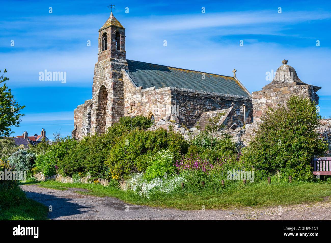 Colourful spring flowers on roadside next to St Mary’s Parish Church in ...
