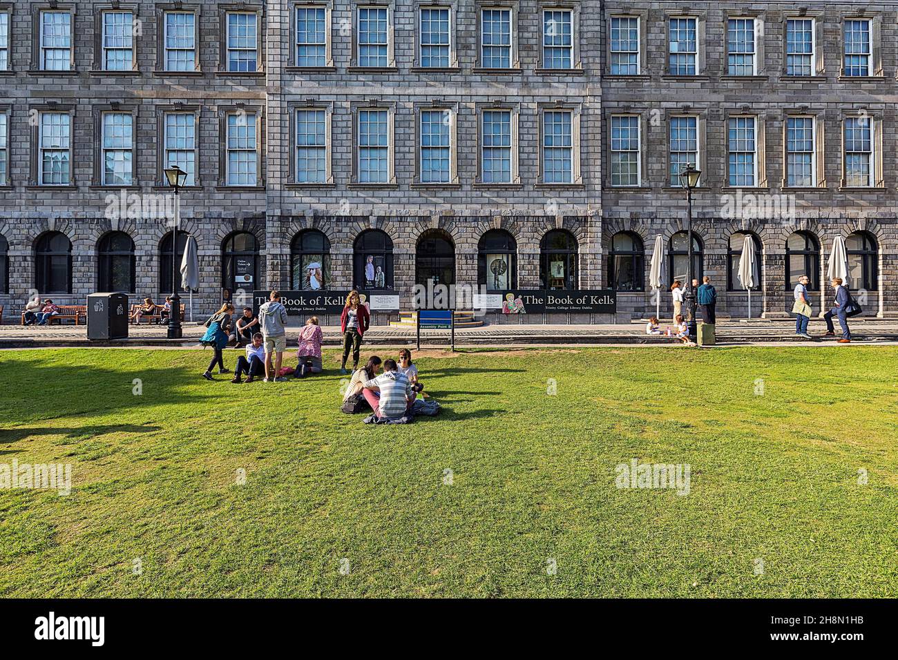 Students on a lawn in front of the library of Trinity College, Dublin ...