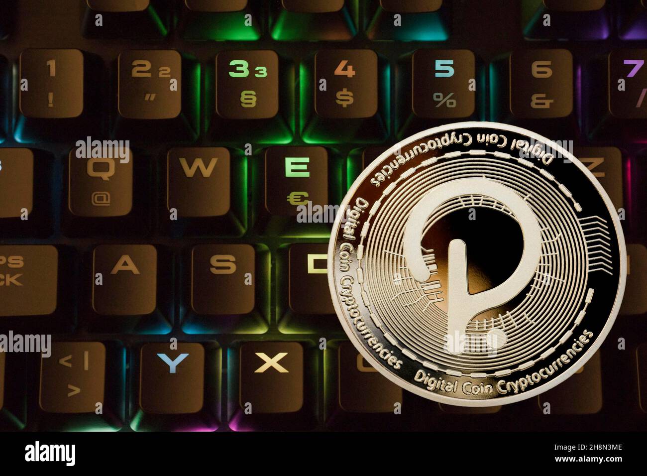 Digital currency lies on a colourfully illuminated computer keyboard ...