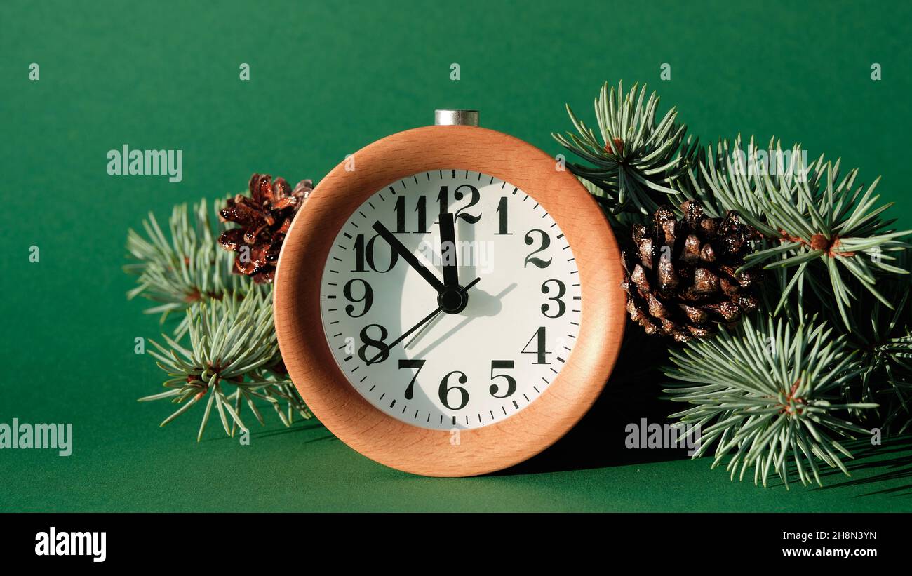 Countdown to midnight. Wood alarm clock with fir tree and pine cones ...