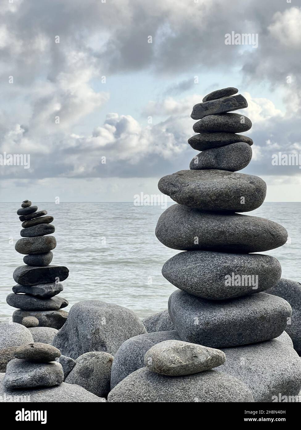 Vertical shot of a stack of stones and sea Stock Photo - Alamy