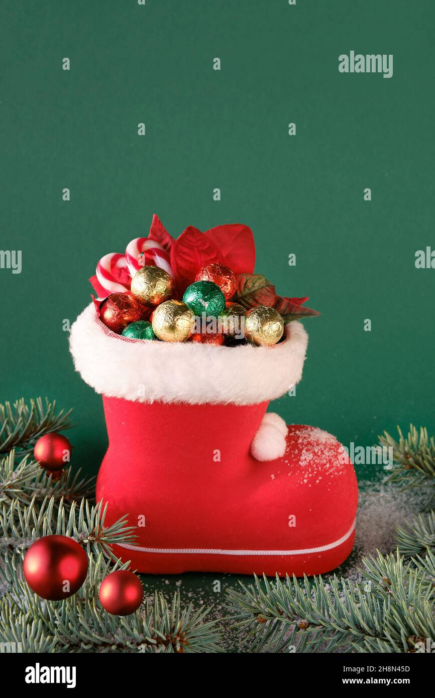 Red Santa boot with chocolate Xmas balls. Wooden word love on red ...
